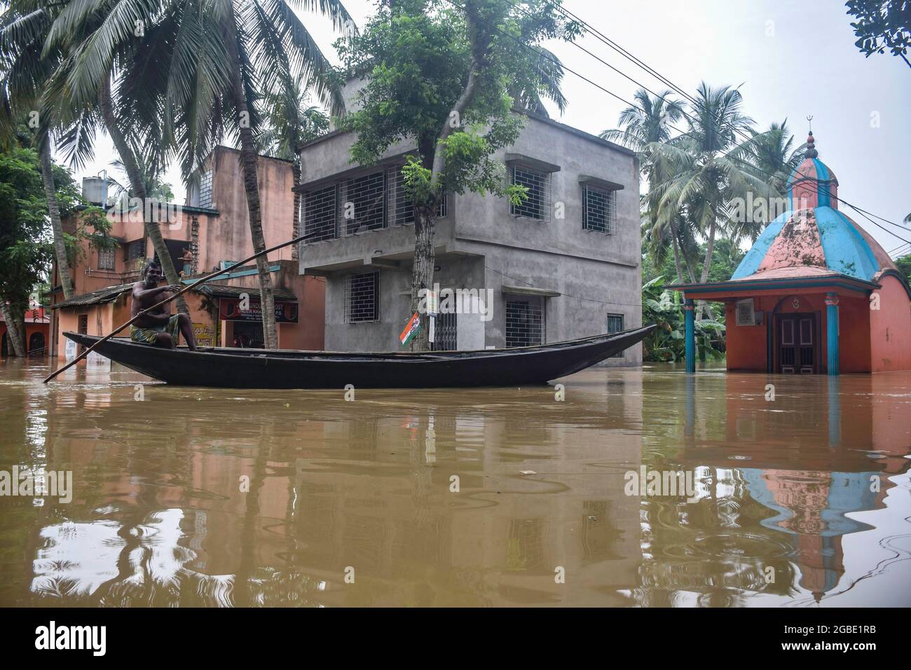 A man uses boat to move through a flooded area in Khanakul. Incessant ...