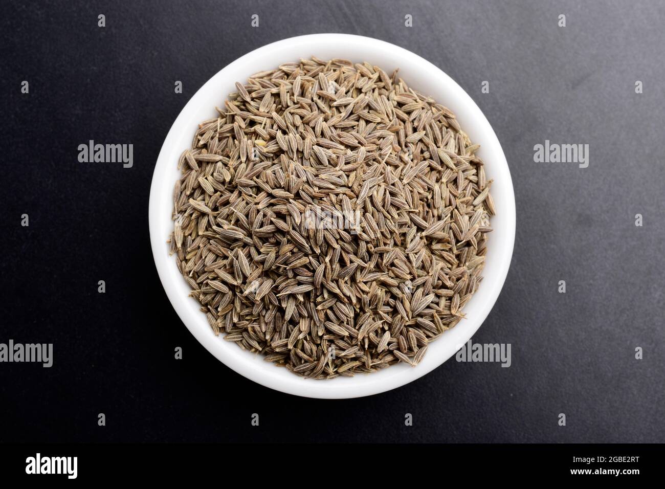 Top View Of Cumin Seeds In Bowl On Black Background Stock Photo - Alamy