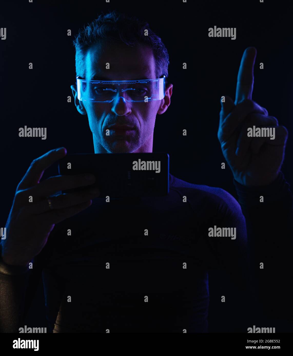 Conceptual portrait of a mysterious guy using a futuristic technology ...