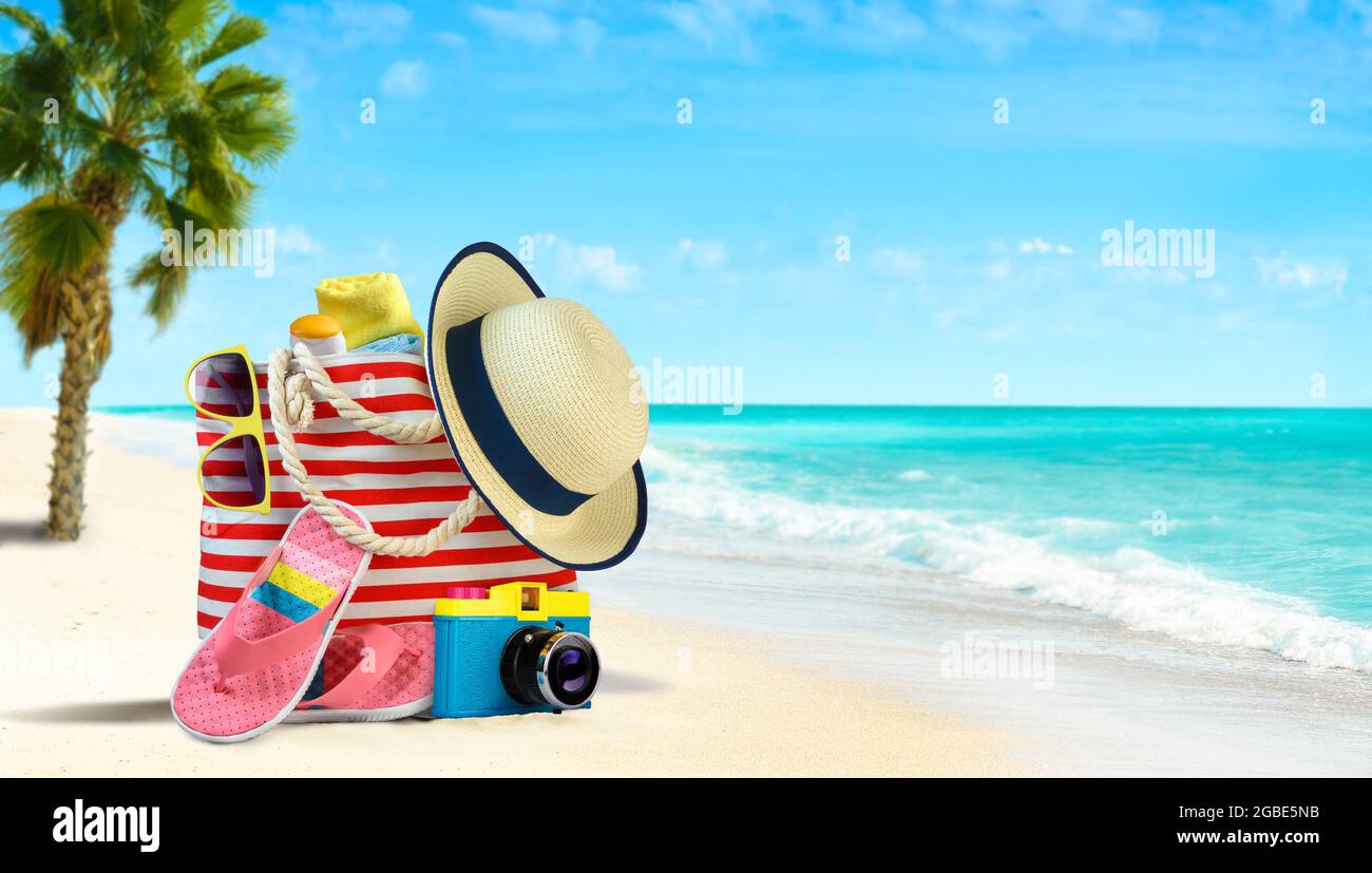 Summer beach bag and accessories - straw hat, flip flops and sunglasses ...