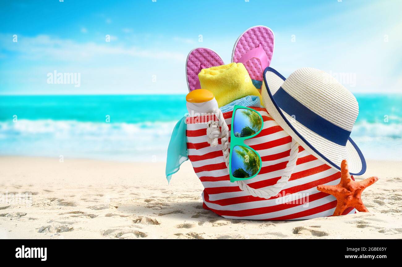 Summer beach bag and accessories - straw hat, flip flops and sunglasses ...