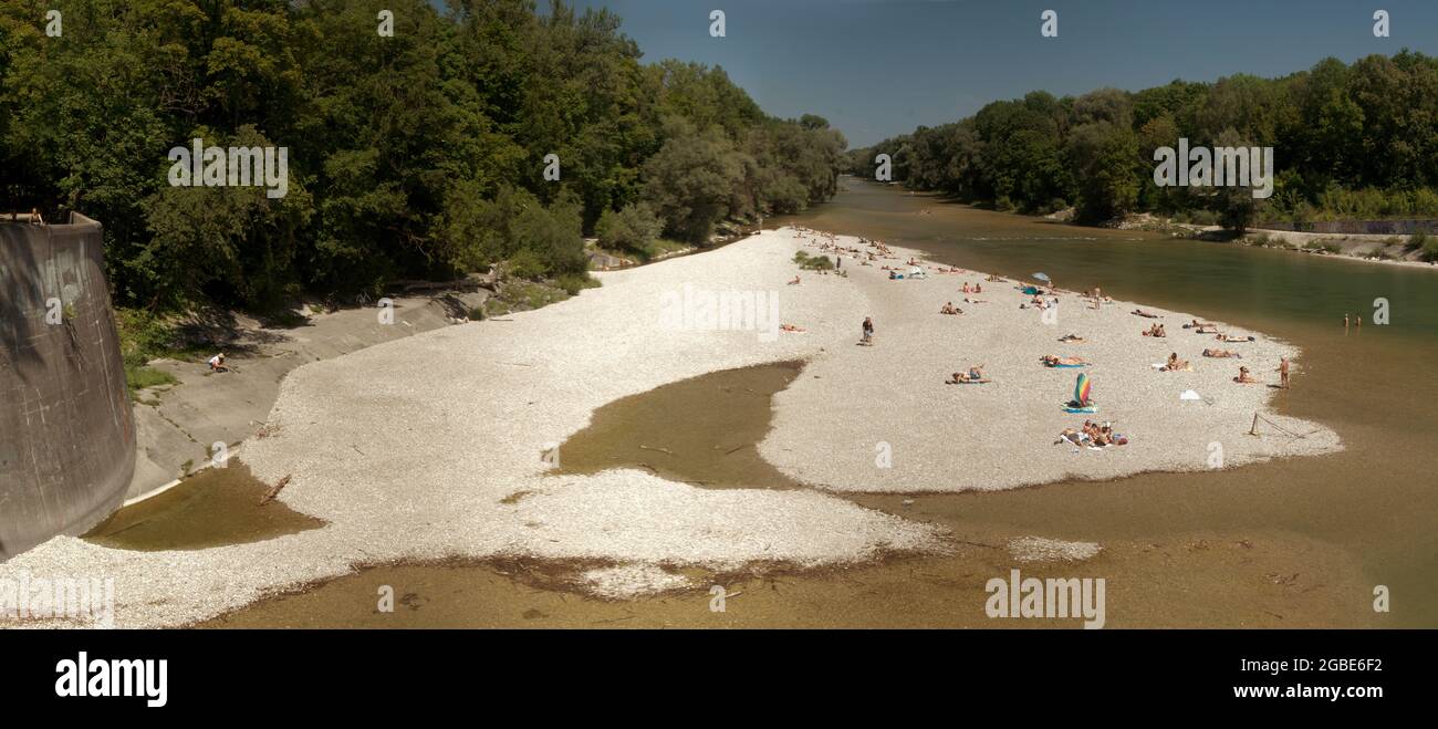 Isar River in München during Summer, with sunbathers on the shingle bed ...