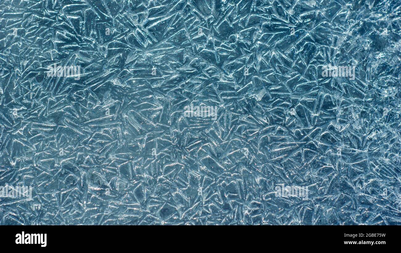 Beautiful ice texture with cracks of a frozen puddle on the asphalt for ...