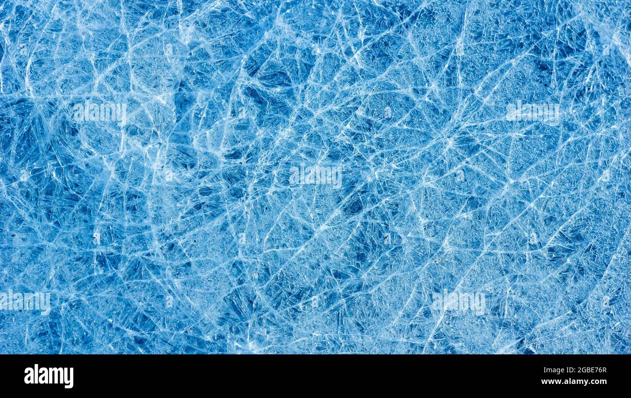 Beautiful ice texture with cracks of a frozen puddle on the asphalt for ...