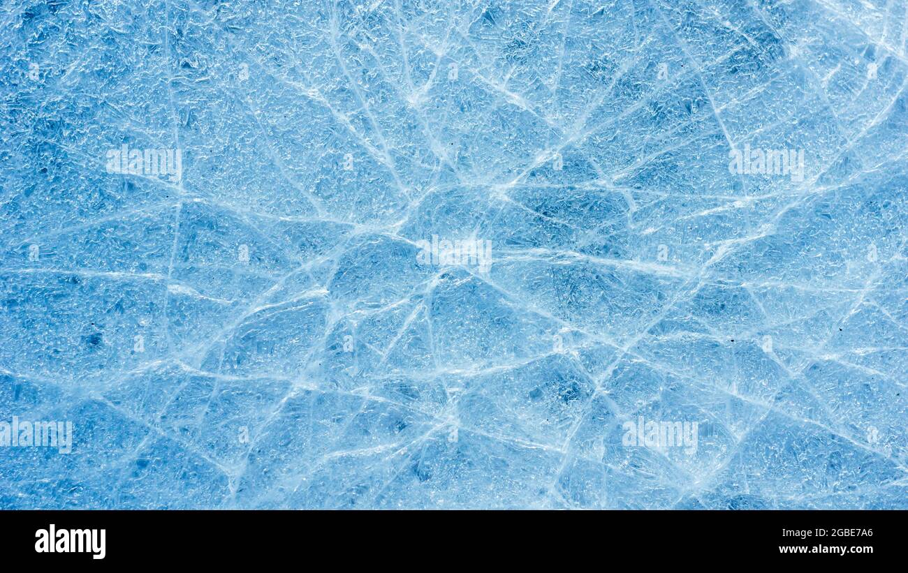 Beautiful ice texture with cracks of a frozen puddle on the asphalt for ...