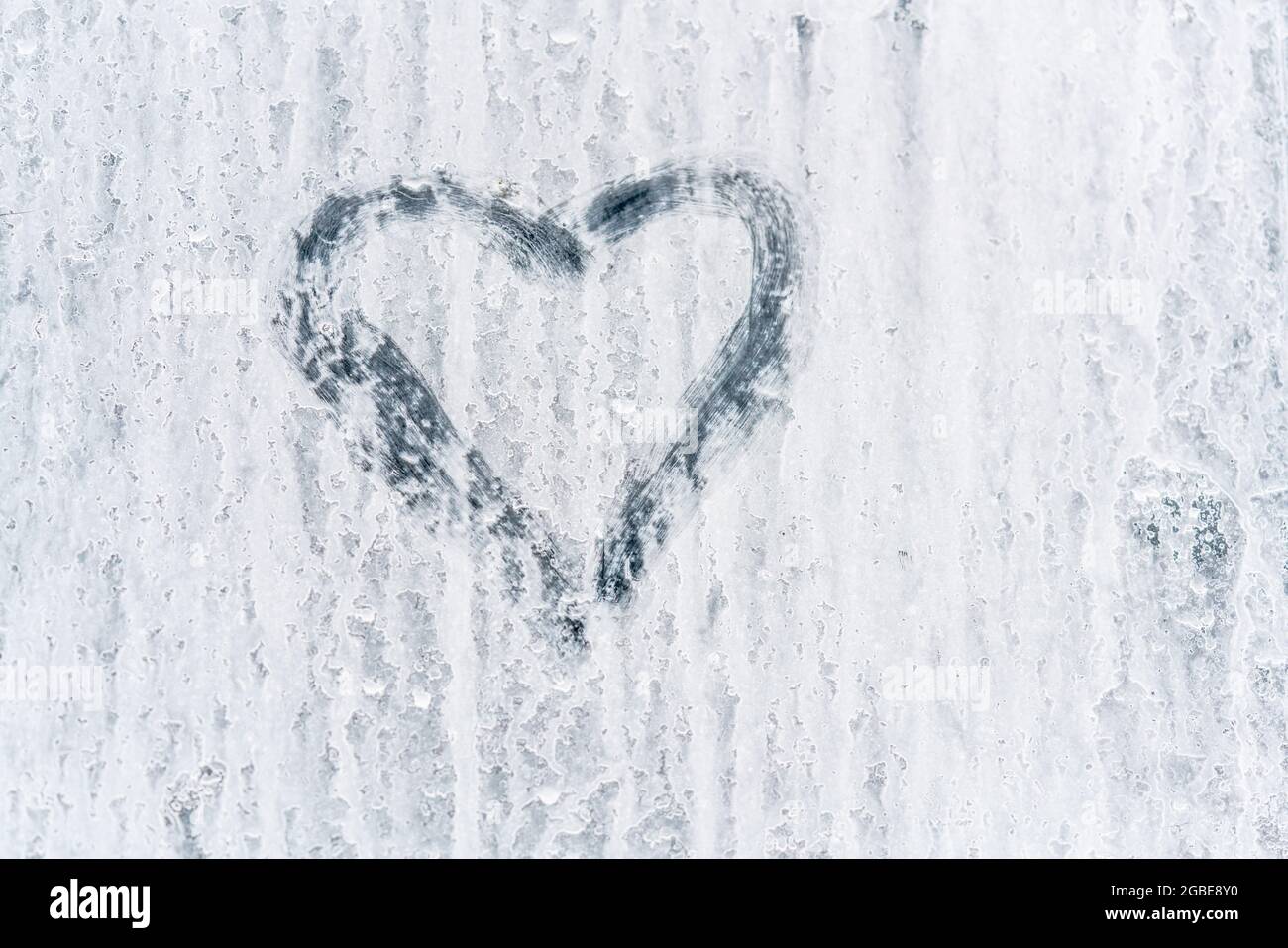 Heart shape hand-drawn on the whitewashed window, a romantic background ...