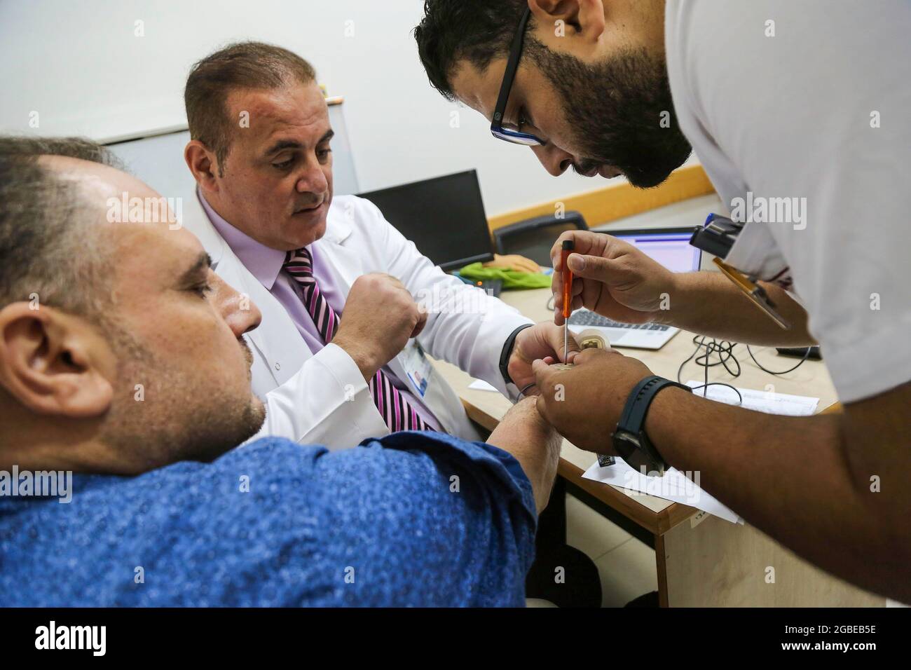Gaza, Palestine. 03rd Aug, 2021. Palestinian doctors check the hand of ...
