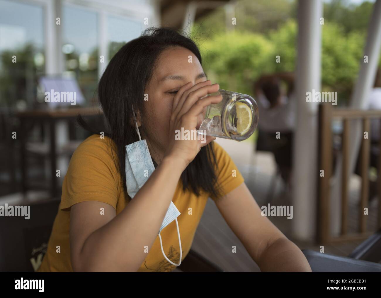Closeup shot of a Hispanic woman drinking a glass of a water in a Stock ...