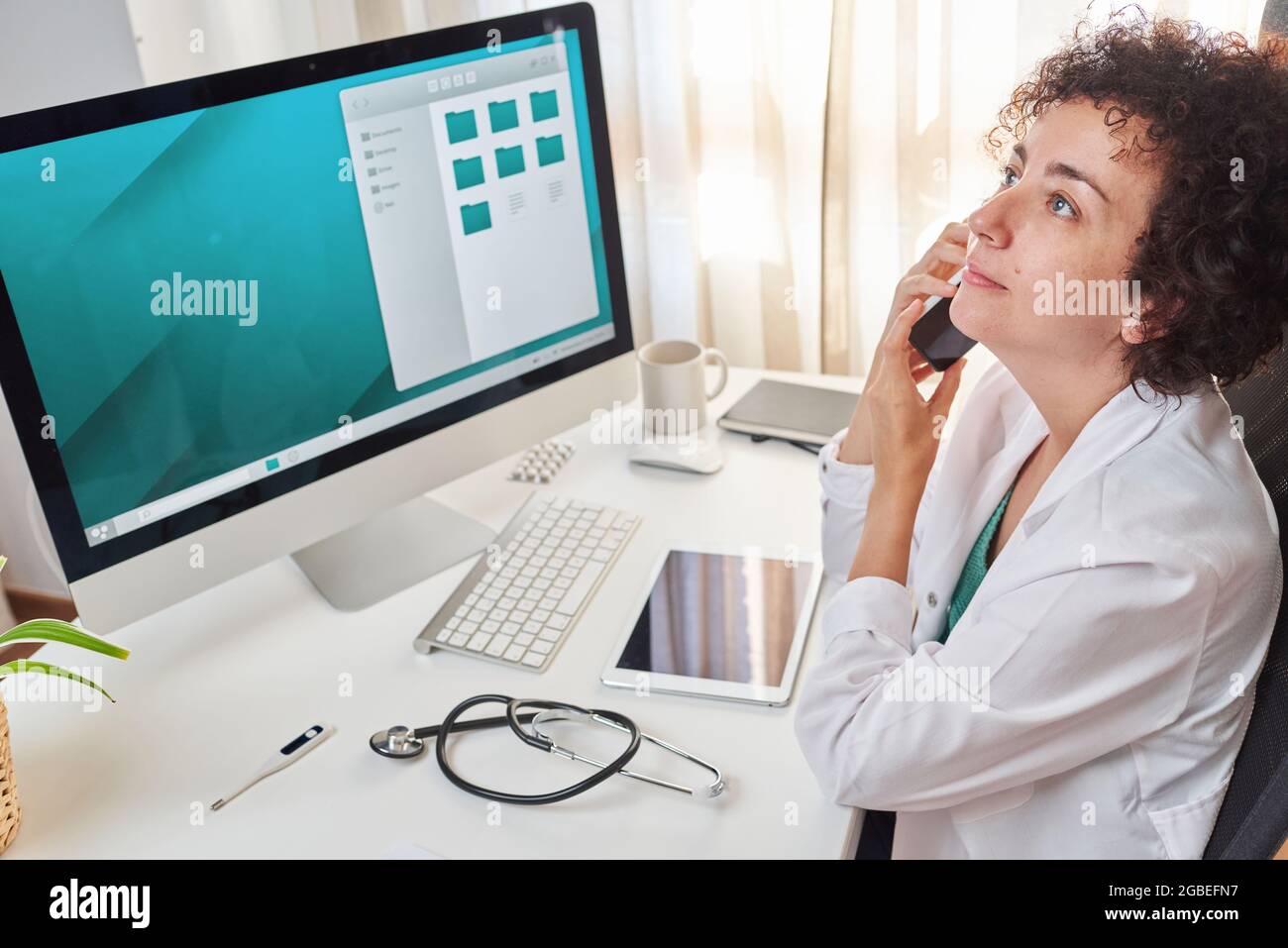 A female doctor answers a phone call from her office Stock Photo - Alamy