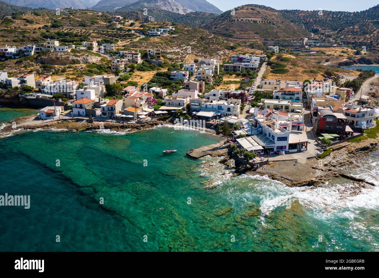 Aerial view of the Cretan village of Mochlos surrounded by crystal ...