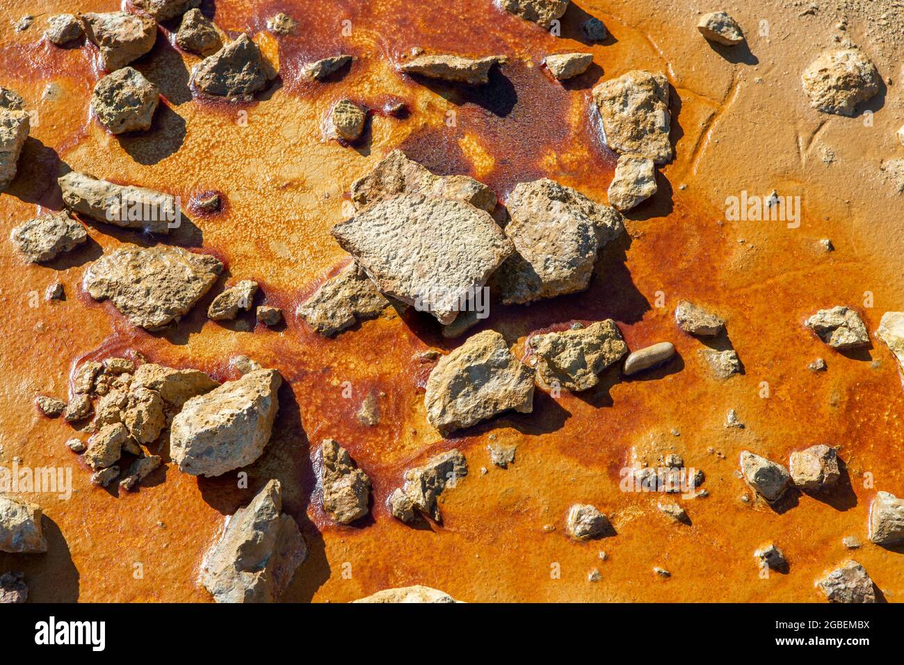 set of different stones on a reddish mud floor illuminated by the sun ...