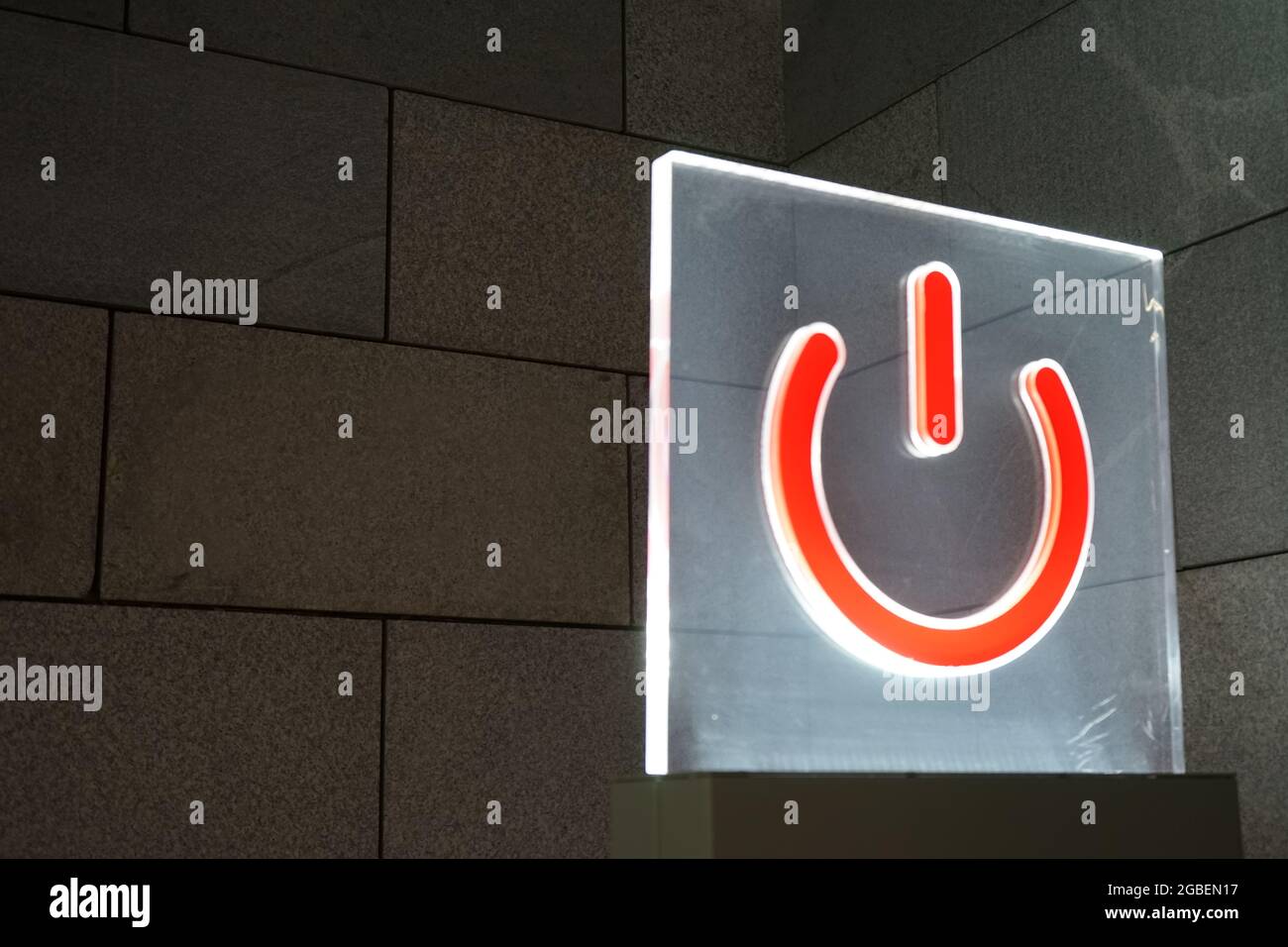 Red power symbol on a transparent surface on a wall background Stock ...
