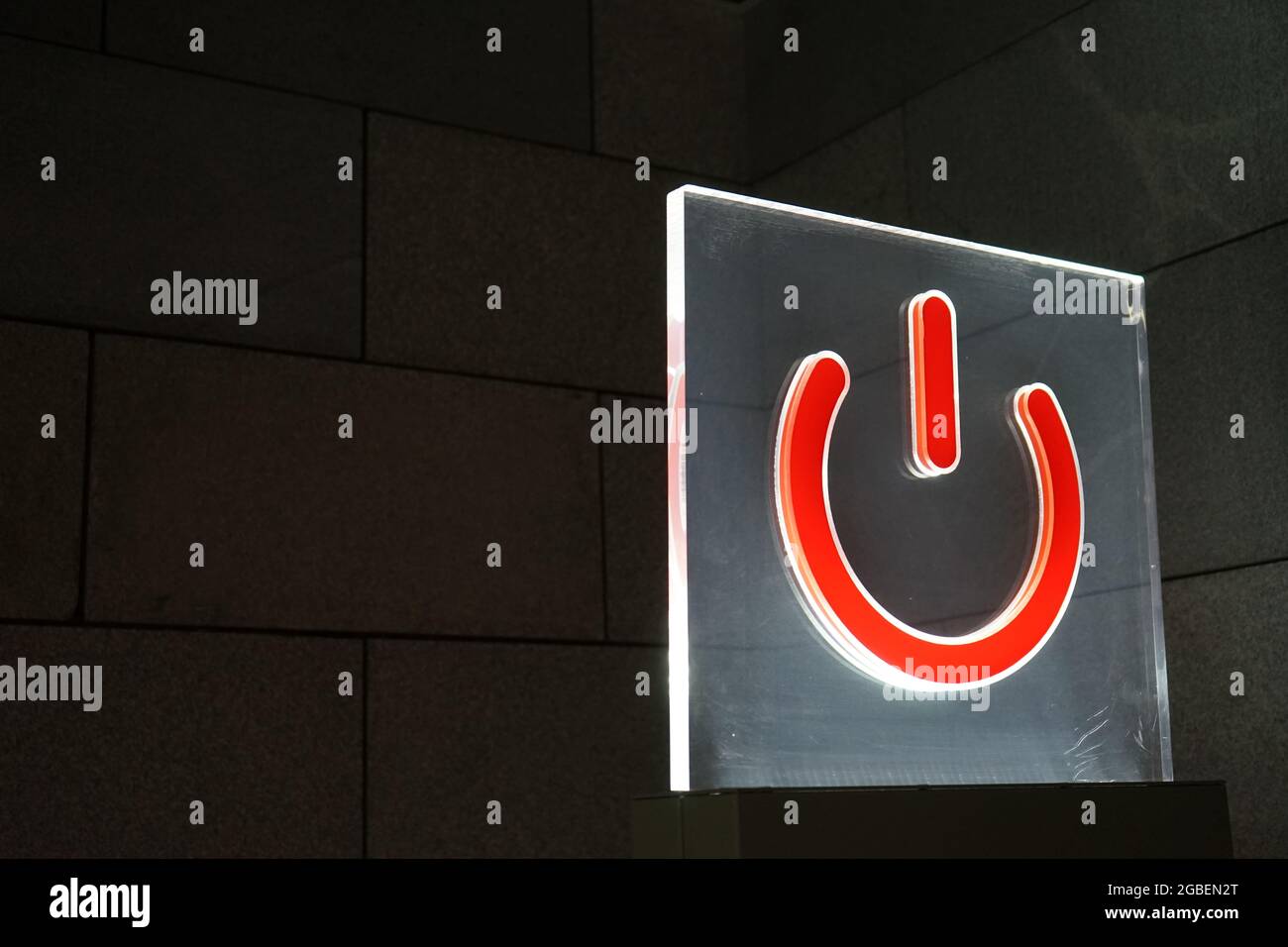 Red power symbol on a transparent surface on a wall background Stock ...