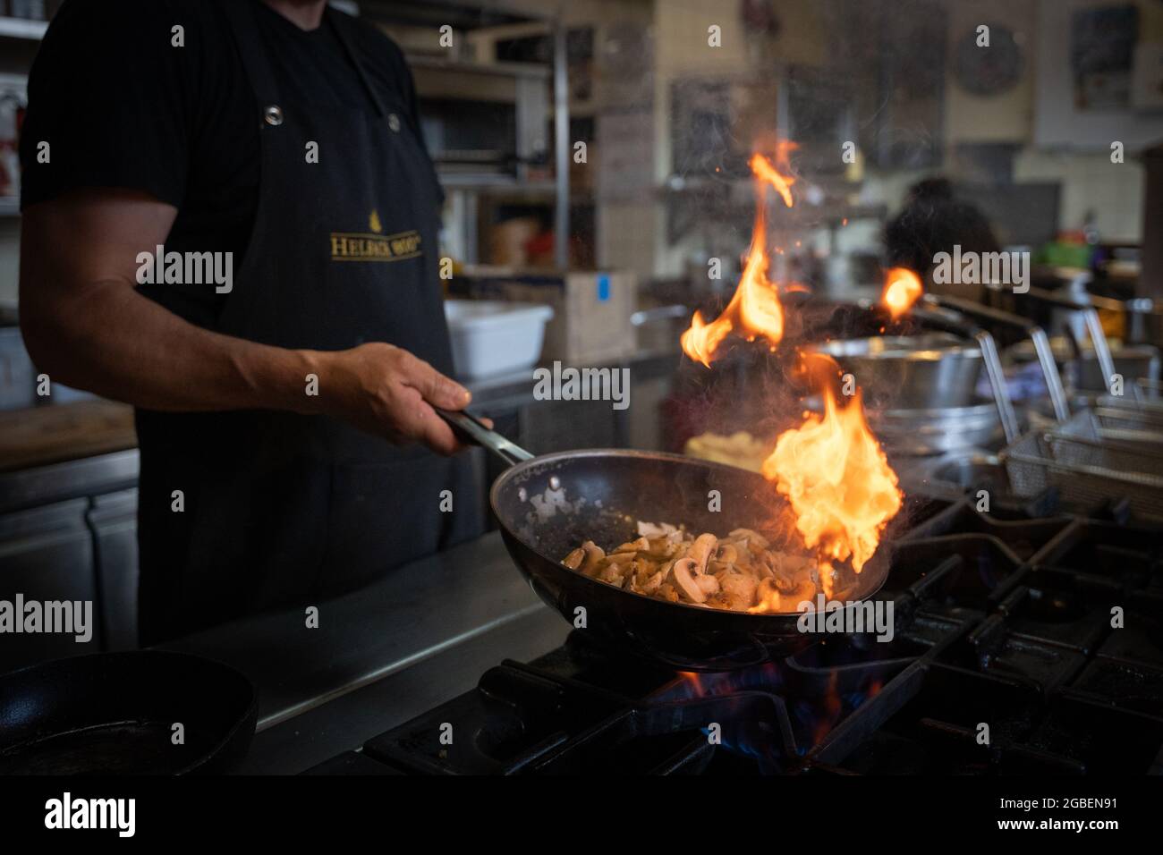 Professional chef making a delicious meal at a restaurant kitchen Stock ...
