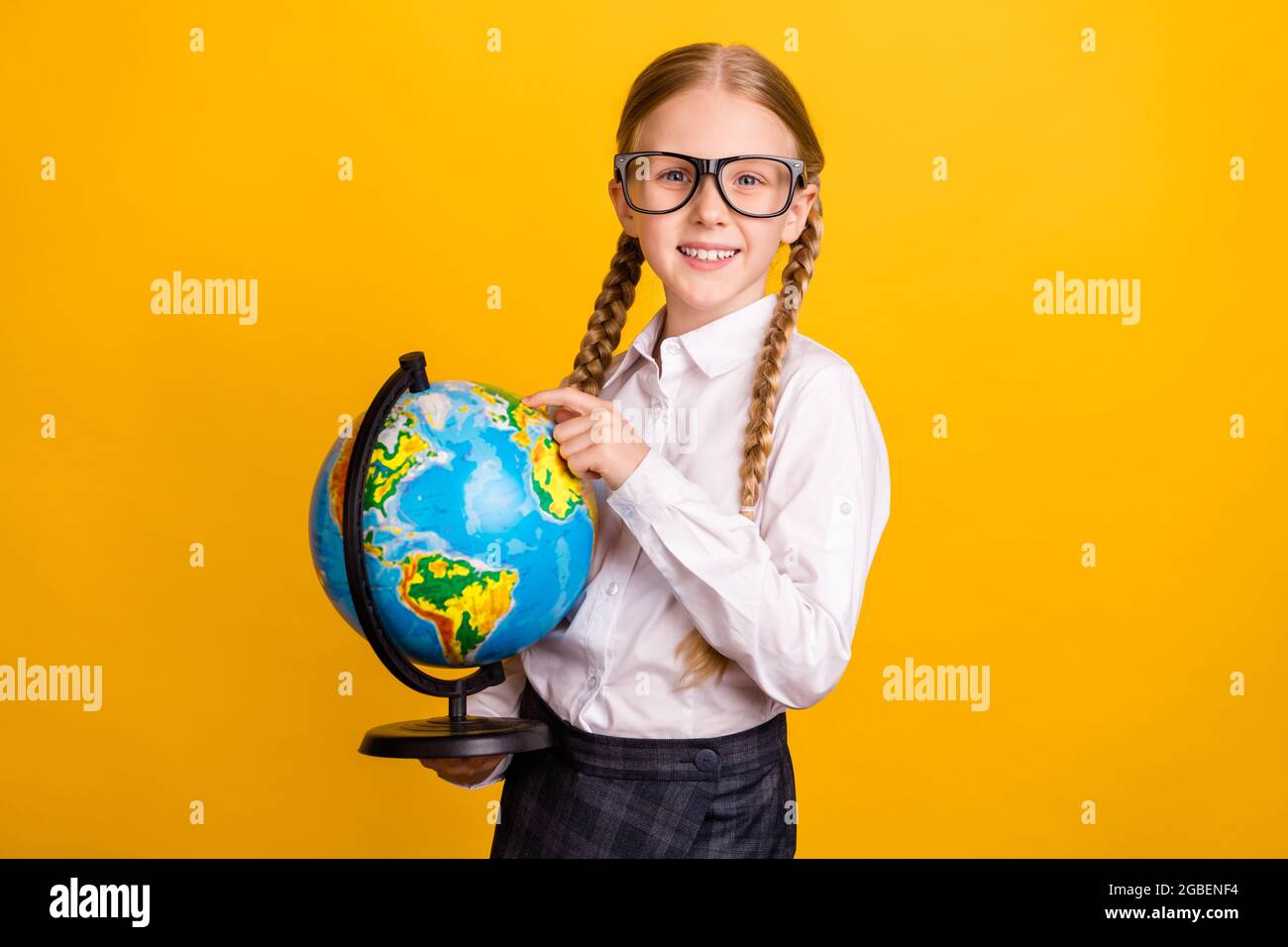 Photo of cheerful satisfied person hold globe finger point pick country ...