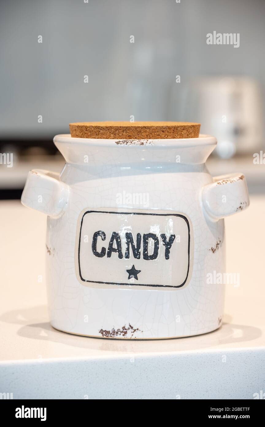 White ceramic candy jar in a modern kitchen with blurred background ...