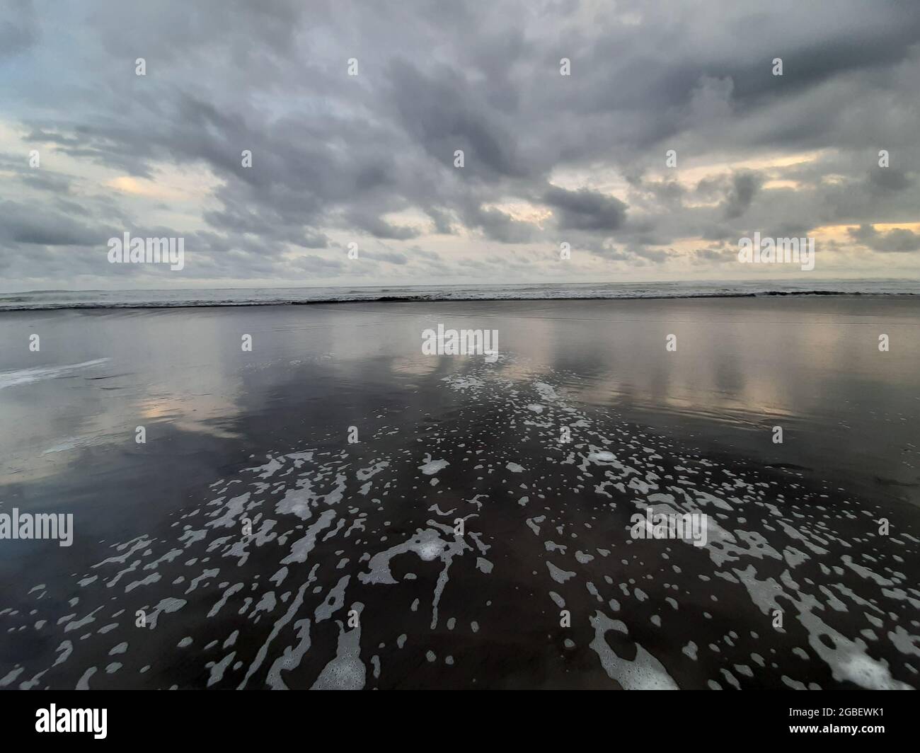 Mesmerizing view of a reflective lake with foam under a cloudy sky ...
