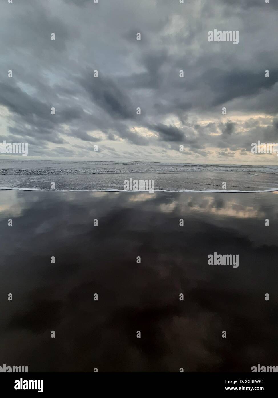 Vertical gloomy shot of a wavy lake under a cloudy sky - for ...