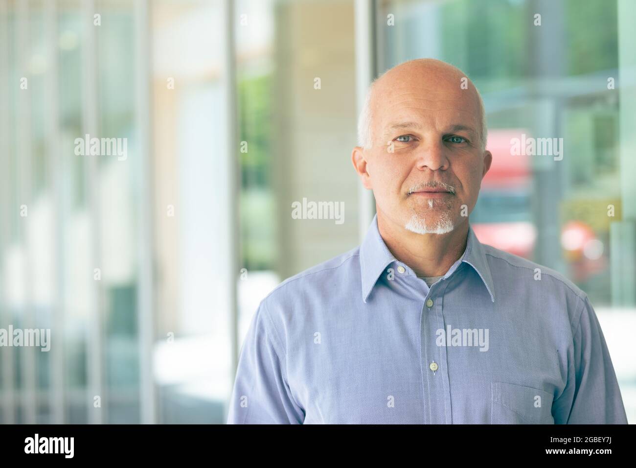 Thoughtful astute businessman staring at the camera with a speculative ...