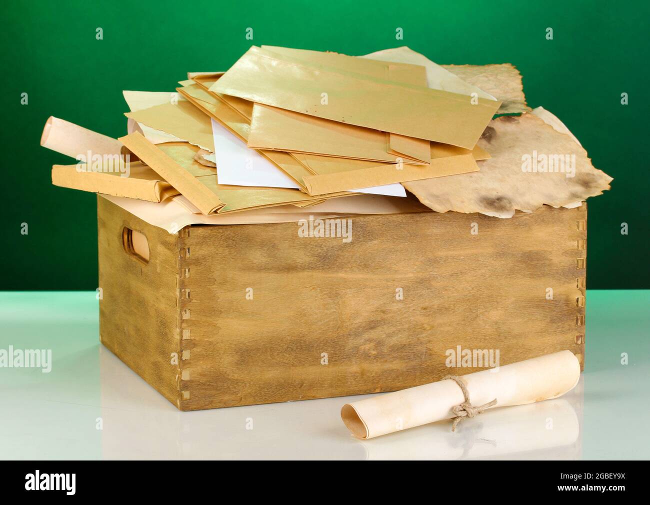 Wooden crate with papers and letters on green background Stock Photo ...