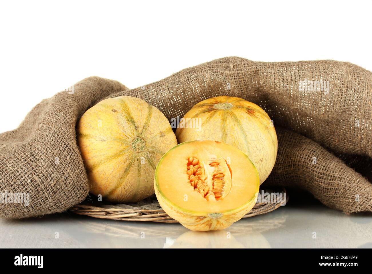cut melon on wicker mat on sackcloth background close up Stock Photo ...