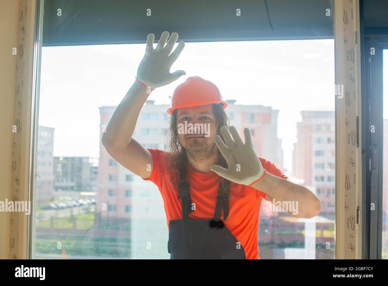 a sad engineer in a helmet stands behind a glass Stock Photo - Alamy