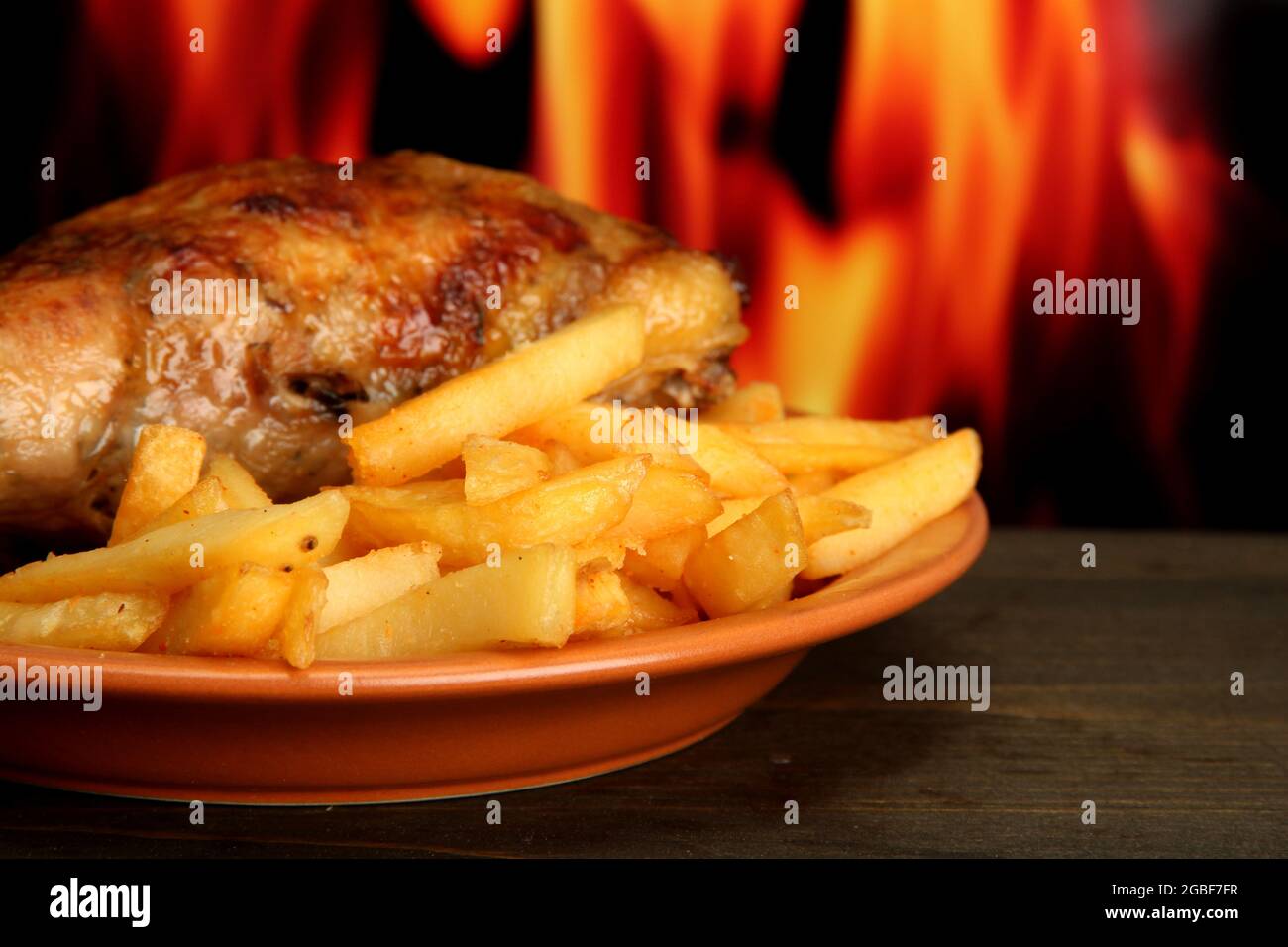 Roast chicken with french fries on fire background Stock Photo - Alamy