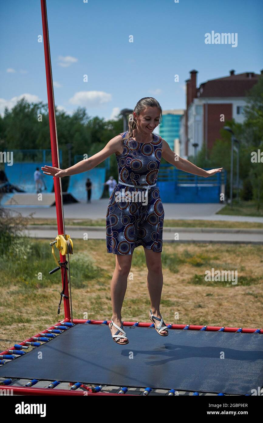 an adult jumping on a trampoline in summer Stock Photo - Alamy