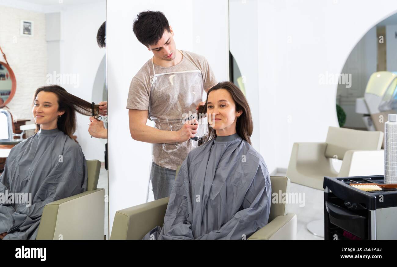 Man doing haircut for woman in salon Stock Photo - Alamy