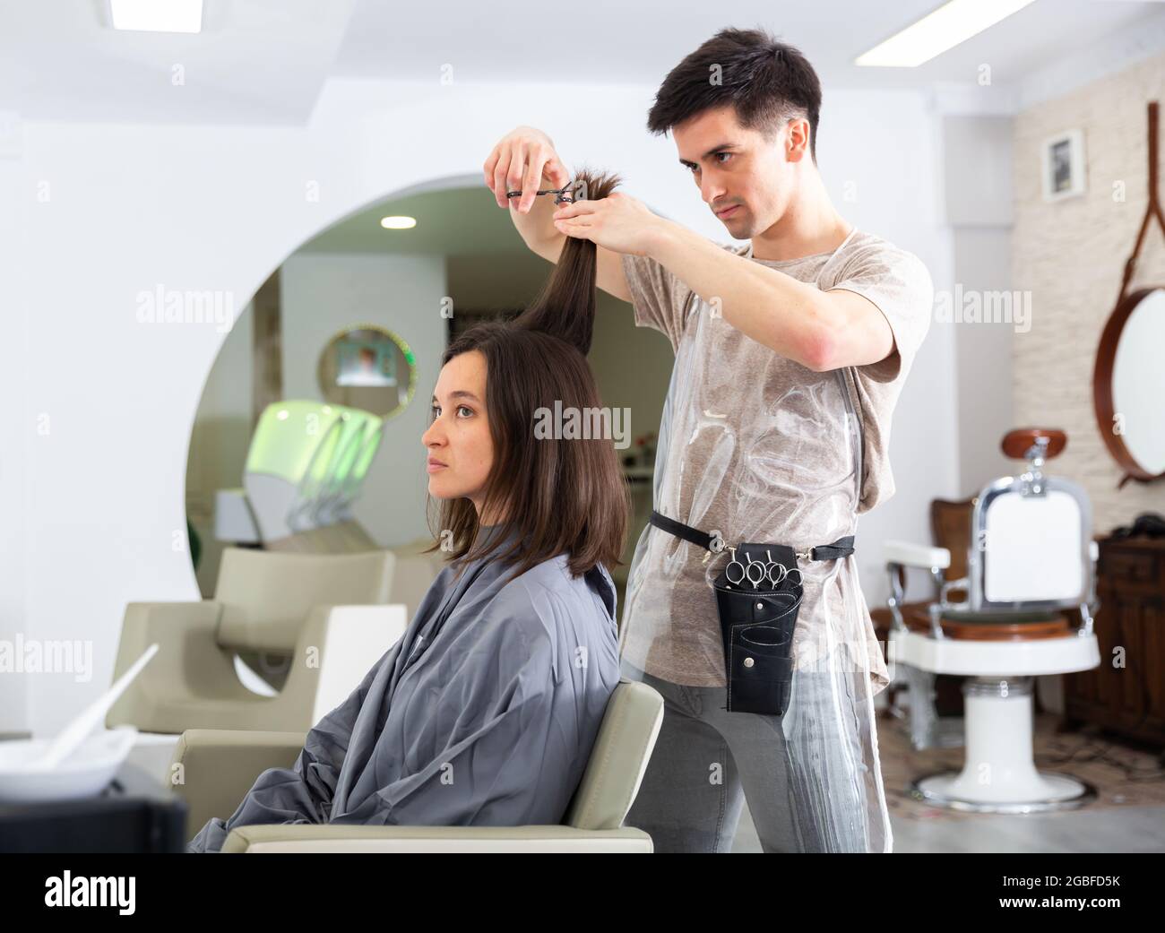 Man doing haircut for woman in salon Stock Photo - Alamy