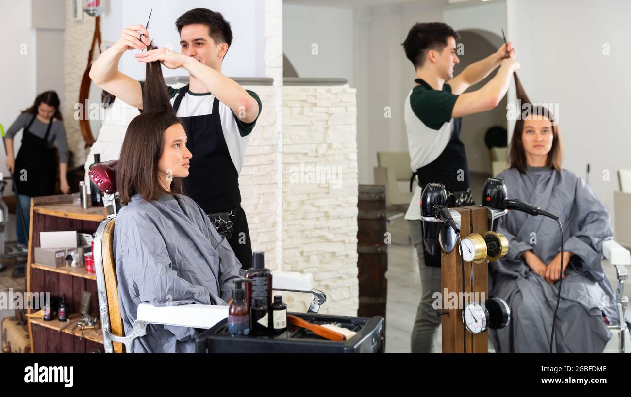 Man professional hairdresser cut female's hair in salon Stock Photo - Alamy