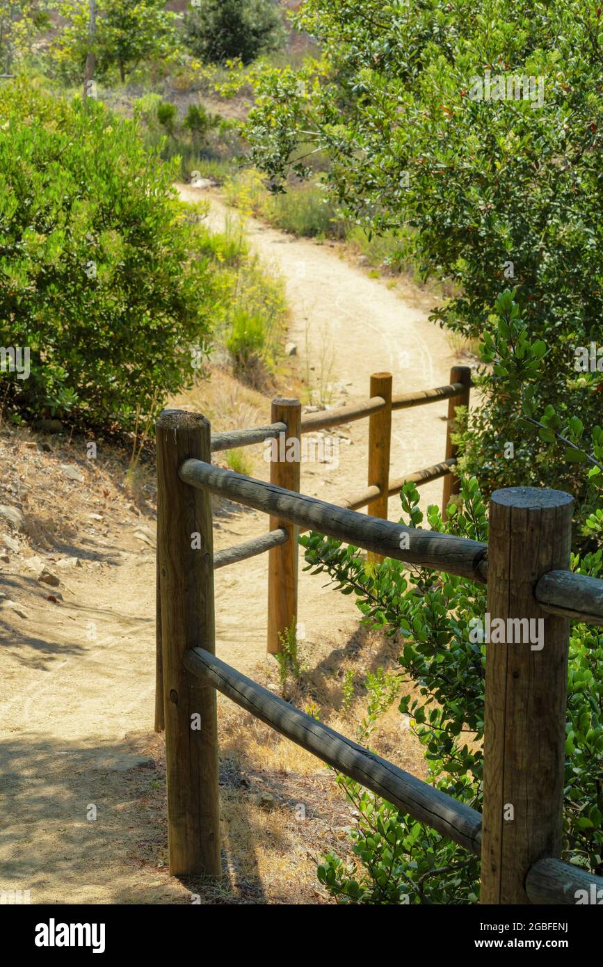 Natural view of a hiking trail with wooden railings Stock Photo - Alamy