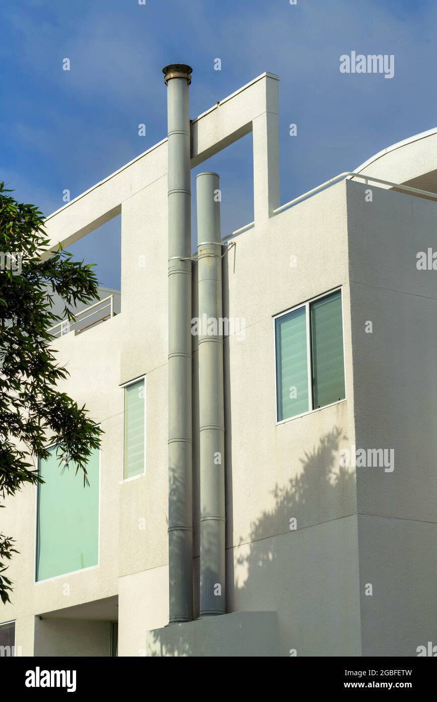 Vertical shot of a white-walled residential building with a long ...