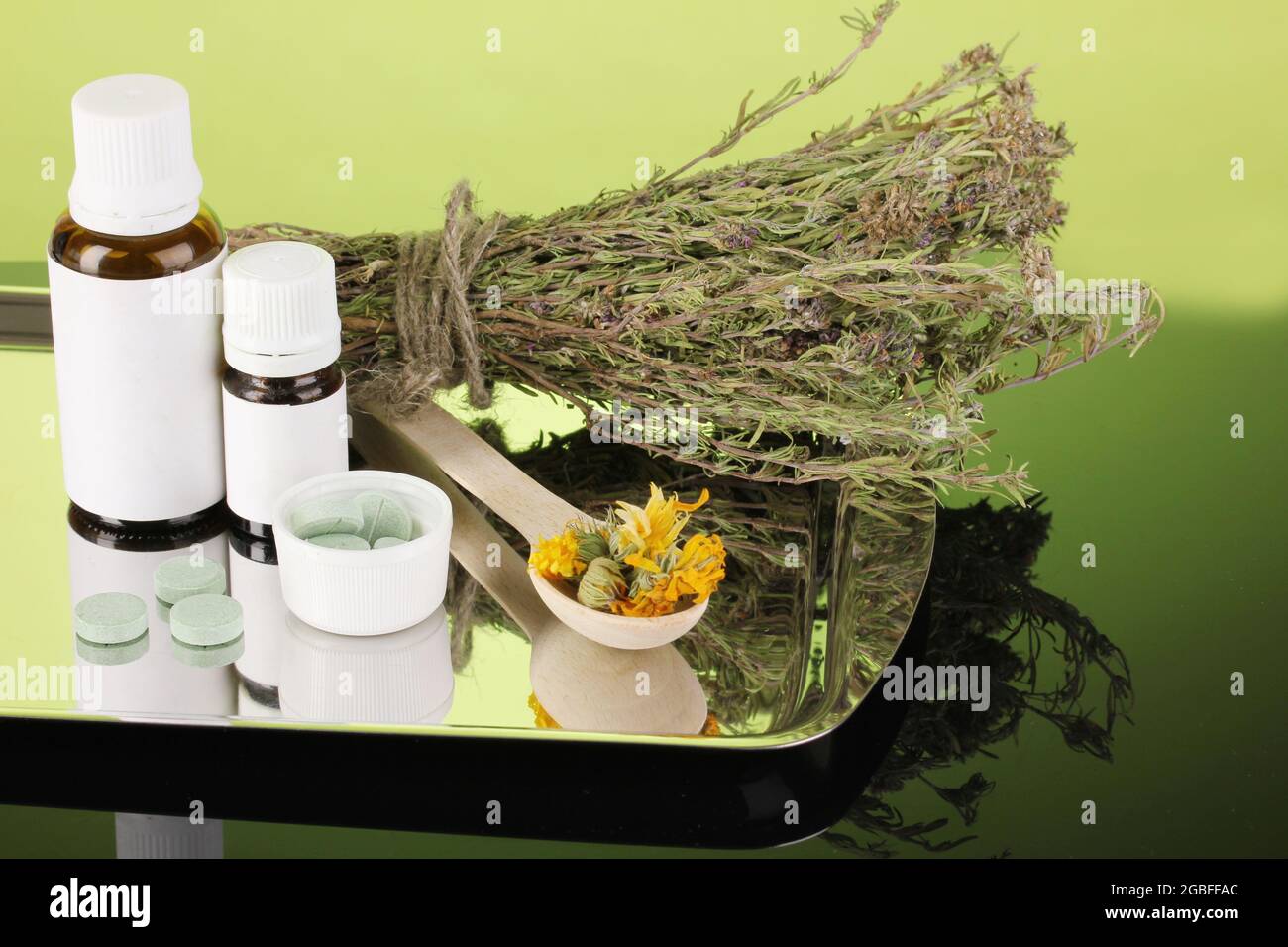 bottles of medicines and herbs on green background. concept of ...