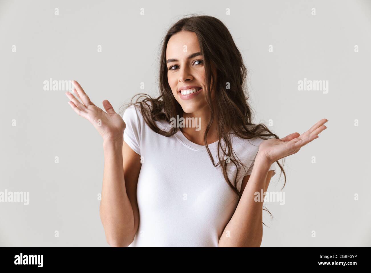 Happy beautiful girl smiling and holding copyspace isolated over white ...