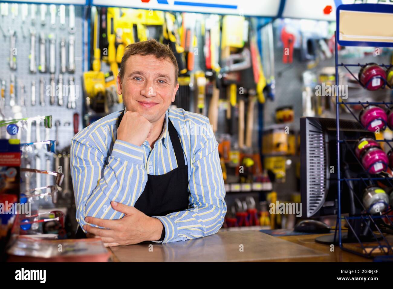 Man seller wearing uniform having tools in hands in store Stock Photo ...