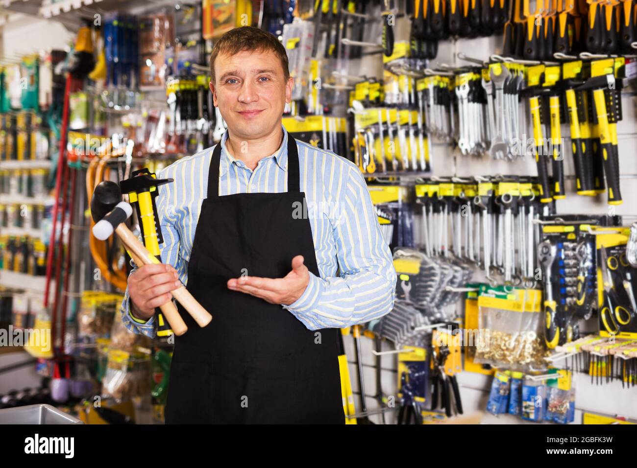 Male seller with tools in store Stock Photo - Alamy