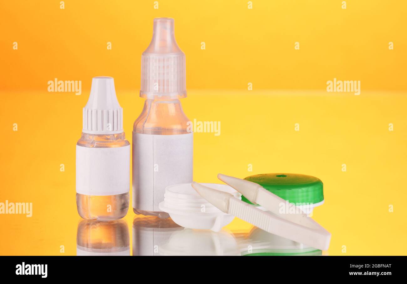 Eye drops and lenses on orange background Stock Photo - Alamy