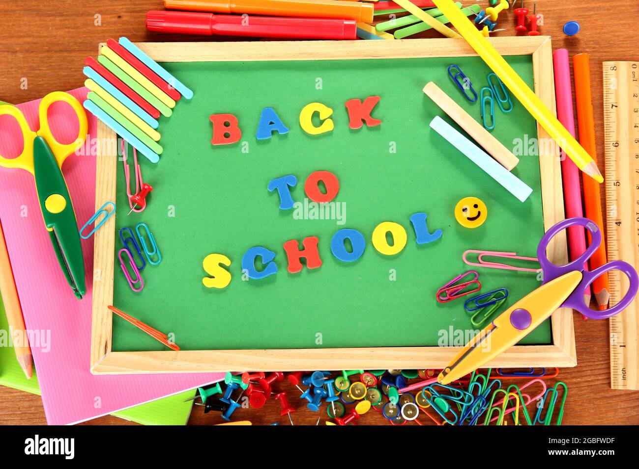 Small chalkboard with school supplies on wooden background. Back to ...
