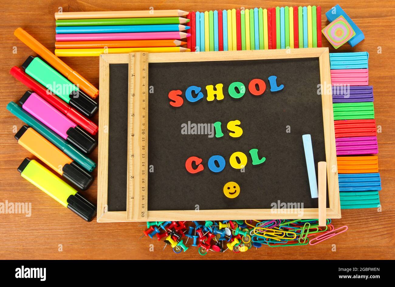 Small chalkboard with school supplies on wooden background. Back to ...