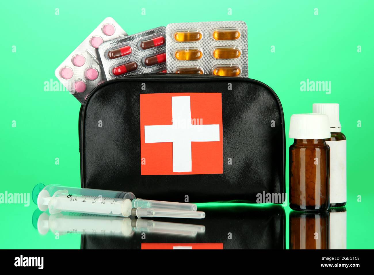 First aid bag, on green background Stock Photo - Alamy