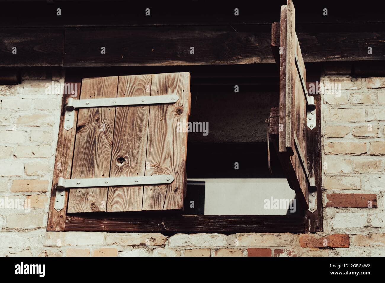Low angle shot of half-opened small wooden doors on a brick wall Stock ...