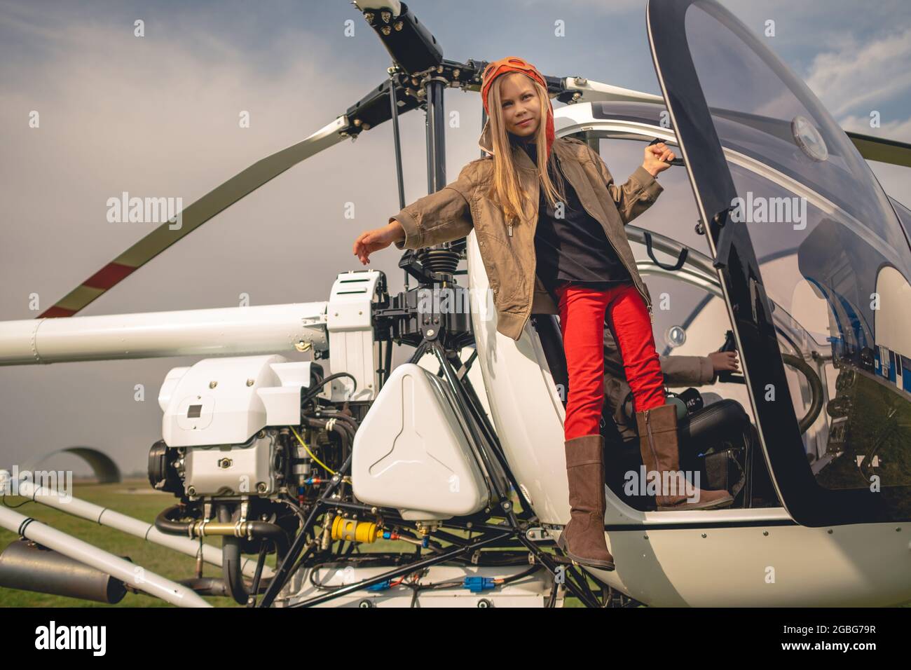 Preteen girl in aviator hat standing in open helicopter cockpit Stock ...