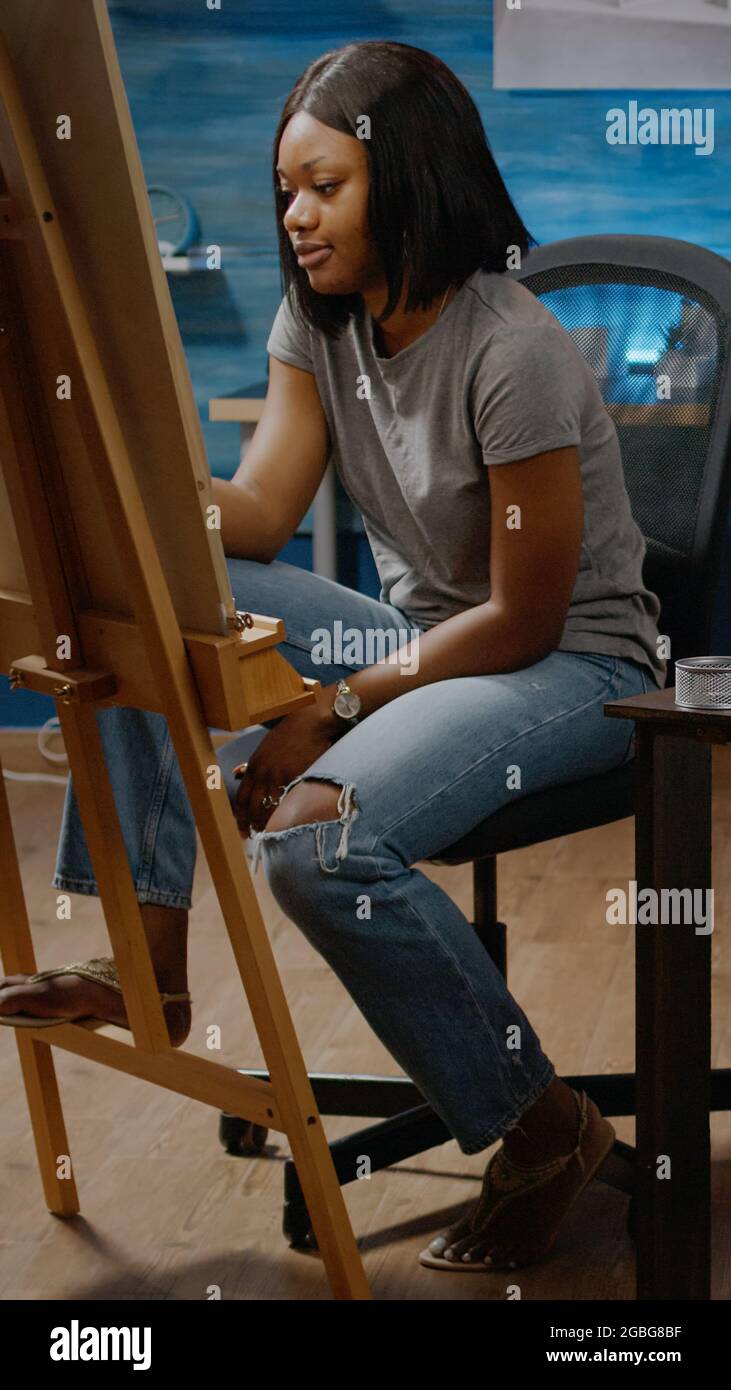 Black artistic person designing masterpiece of vase on table in artwork ...