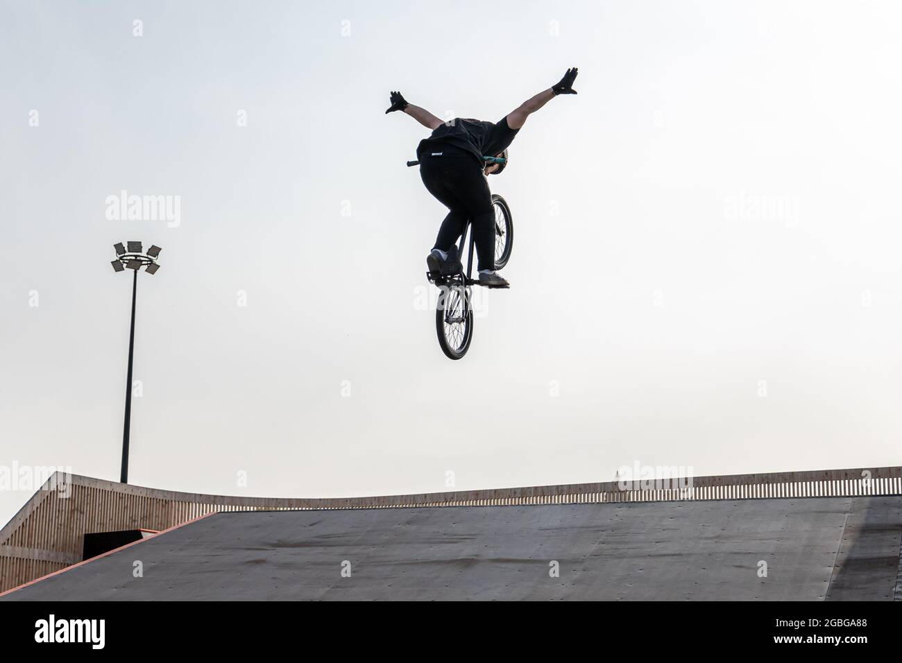 Kazan, Russia - September 26, 2020: A young rider on a BMX bike does tricks in the air. BMX ...