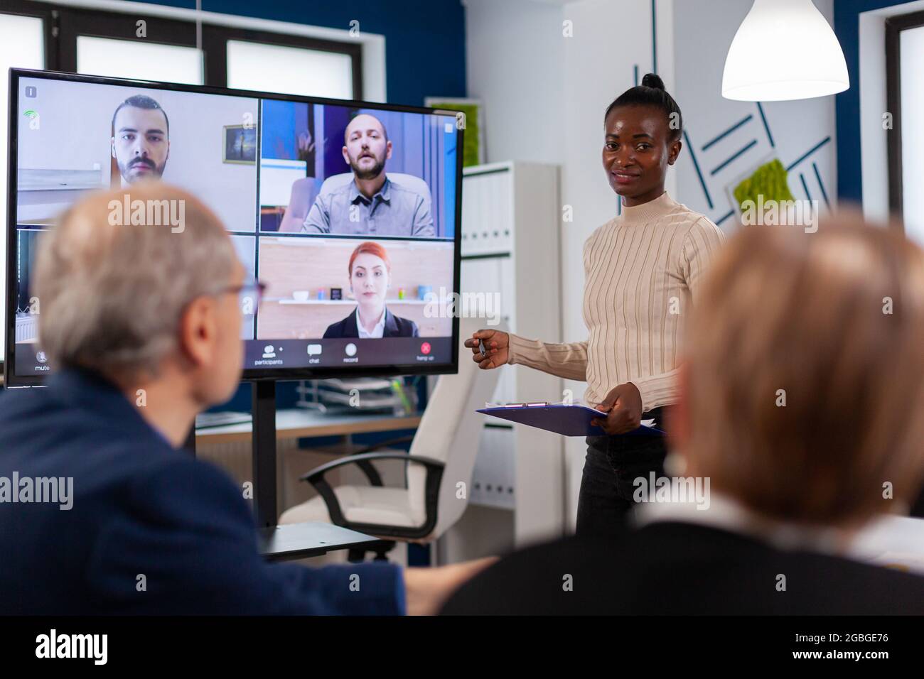 African woman discussing with remote managers on video call presenting ...