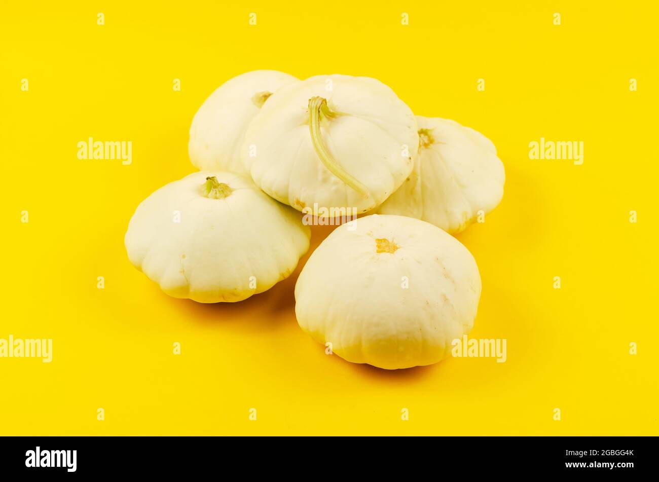 Five White raw fruit Pattypan squash on a yellow. Passionfruit is rich ...