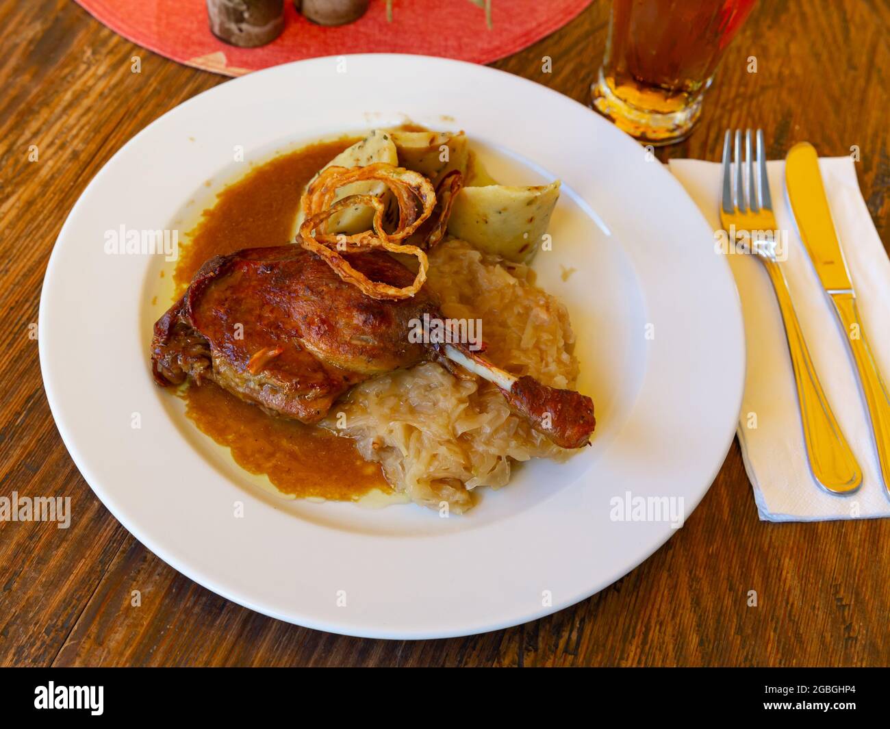 Roasted confit du canard with sauerkraut, potato dumplings and onion ...