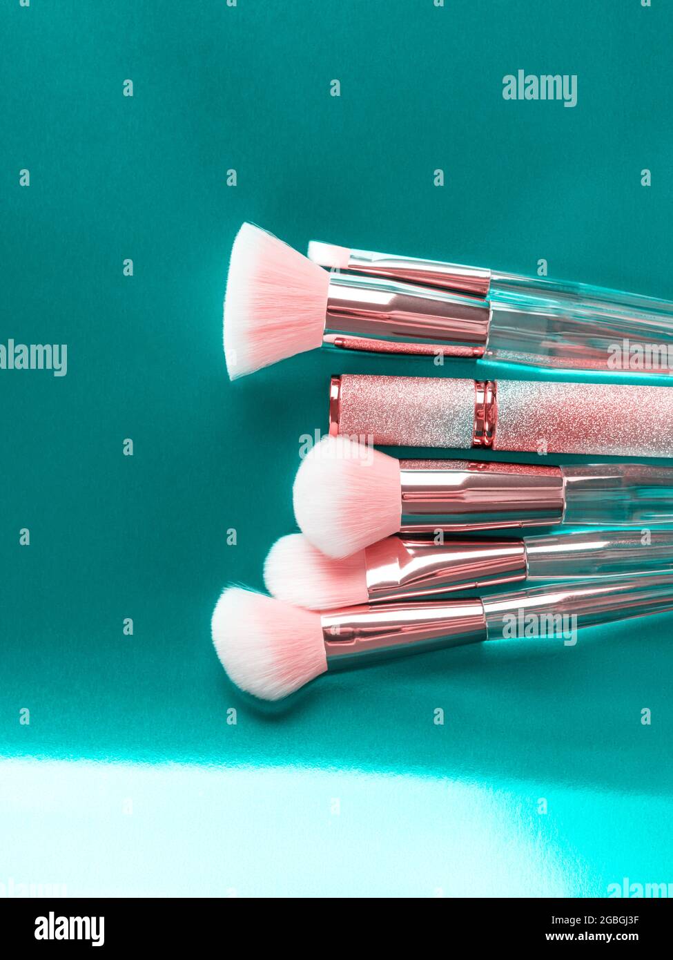 Trendy make up shiny pink brushes on green metallic background Stock ...