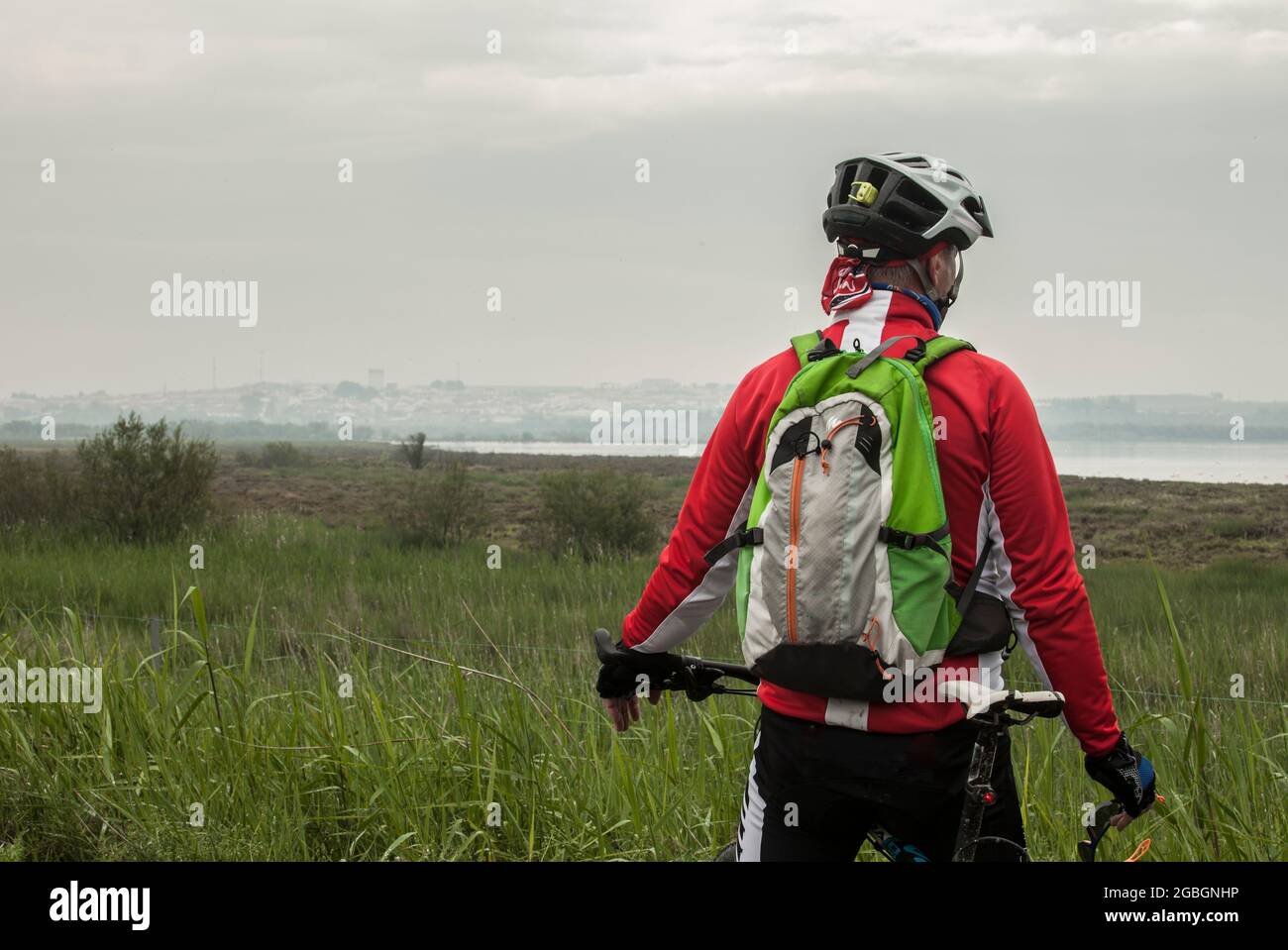 Elder MTB biker observing Flamingos at Fuente de Piedra lagoon, Malaga ...